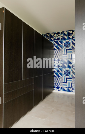 a kitchen with wood flooring and white cupboards on the wall behind it ...