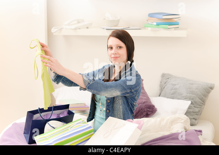 Young happy attractive girl unpack shopping bags in student appartment ...