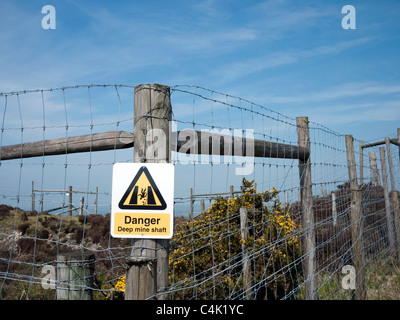 Warning sign above old mine shaft Stock Photo - Alamy