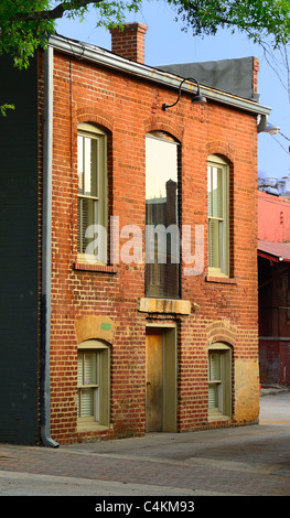 A old run down brick alleyway with a iron stairway in black and white ...