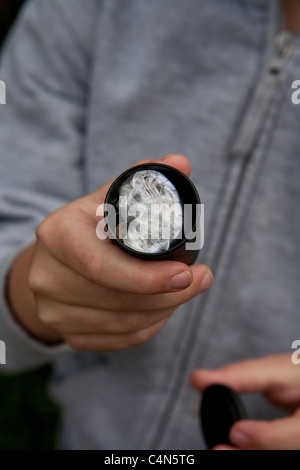 A boy examining the contents of a micro-cache Stock Photo - Alamy