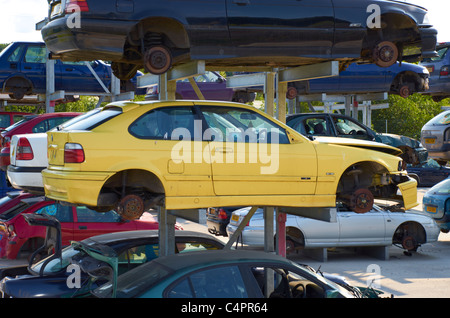 Old smashed up cars stacked high in breakers yard Stock Photo - Alamy