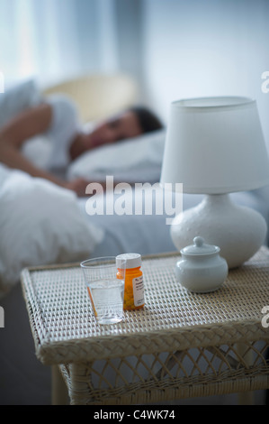 Sleeping pills on table in man's bedroom Stock Photo - Alamy