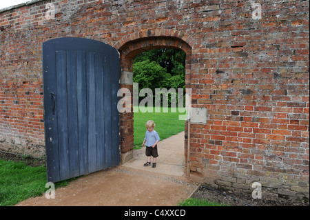 Toddler walking through garden gate left wide open uk Stock Photo - Alamy