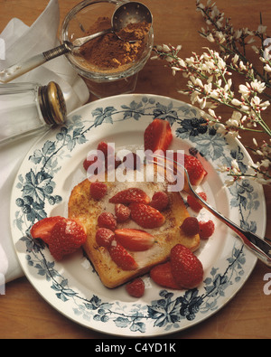 Baking dish with strawberry cinnamon rolls and cream on light ...