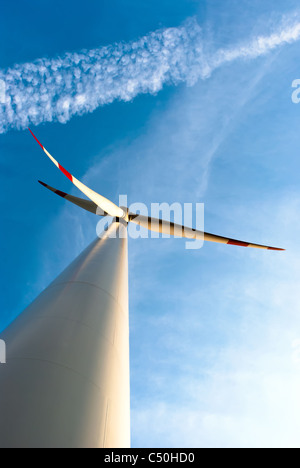 Wind green energy. Wind turbine stands tall against a clear blue sky ...