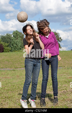 Teenage girl heading football Stock Photo - Alamy