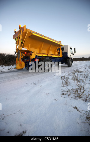 Gritter spreading grit over a snow covered lane, UK Stock Photo - Alamy