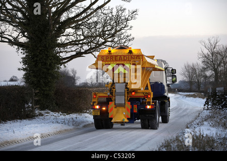 Gritter spreading grit over a snow covered lane, UK Stock Photo - Alamy