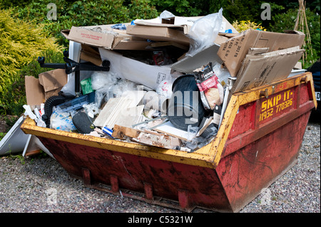 builders waste disposal skip overflowing with rubbish Stock Photo - Alamy