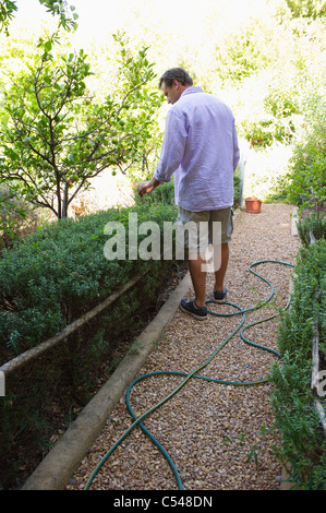 Rear view of man standing by tree trunk against Chush Falls Stock Photo ...