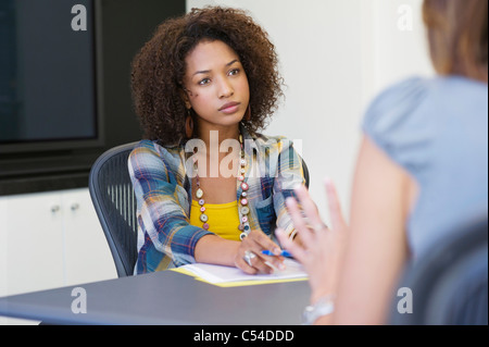African American woman taking an interview of a woman Stock Photo - Alamy