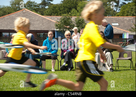 Parents watching their children compete at a Primary school sports day ...