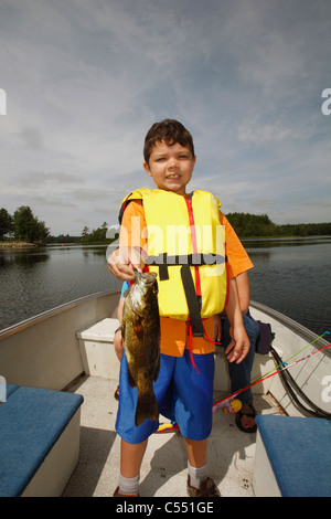 Boy on boat outdoors with fish Stock Photo - Alamy