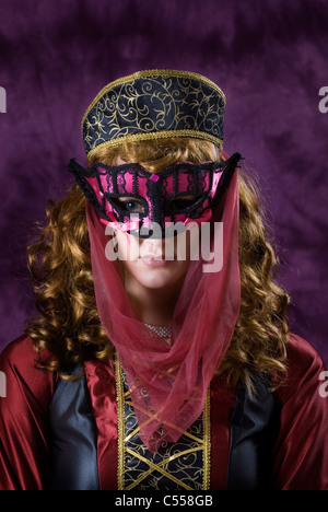 A woman wearing a medieval red dress posing against historical ancient ...