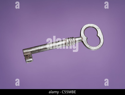 Old metallic key on lila background Stock Photo - Alamy
