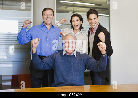 Portrait of business people cheering with arms raised in crowd Stock ...