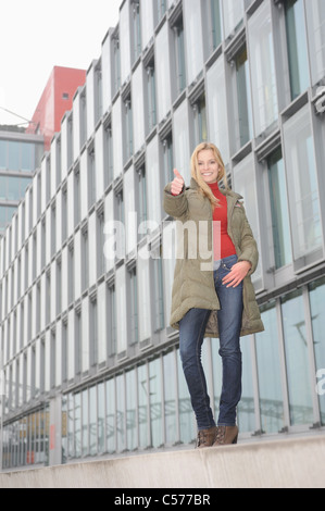 Woman giving thumbs up on blue background Stock Photo - Alamy