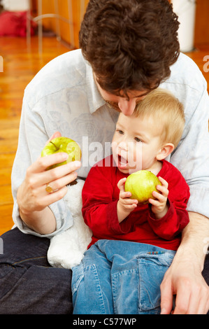 Father and son eating apple Stock Photo - Alamy