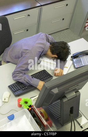 Office worker slumped on his desk Stock Photo - Alamy