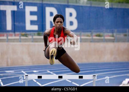 Girl jumping over hurdle on showjumping competition Stock Photo - Alamy