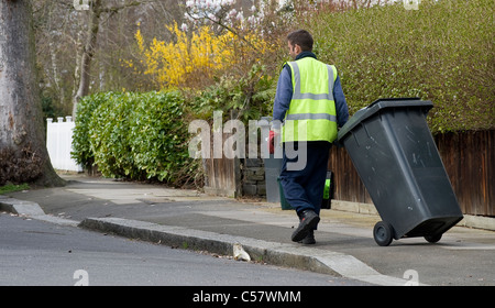 worker collecting bins with refuse recycling collection truck driving ...