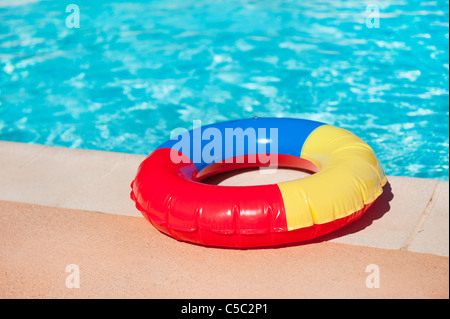 Colorful toy swimming tire at the pool, blue water Stock Photo - Alamy