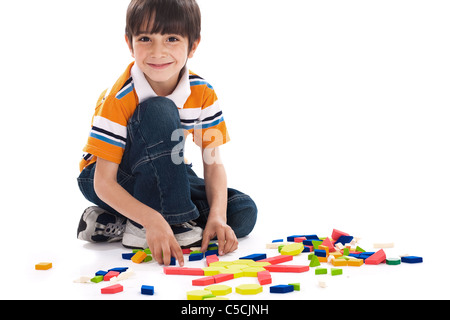 Adorable caucasian boy joining the blocks while playing on white ...