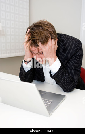 Frustrated man looking at computer screen sitting at the desk Stock ...