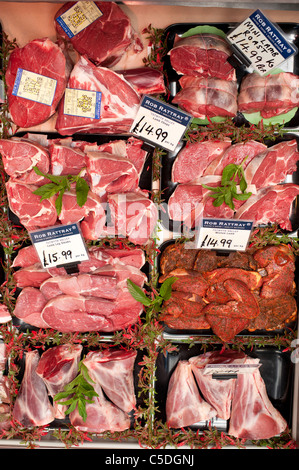 Butchers shop window with various raw joints of meats on display ...