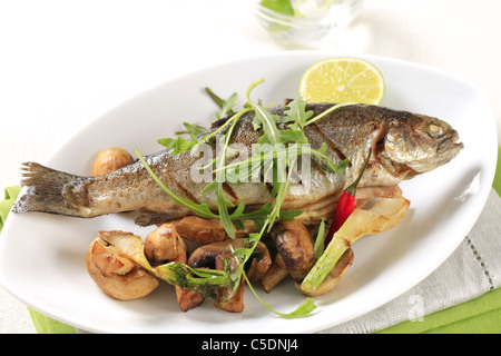 A closeup of fried fish with greens served on a plate Stock Photo - Alamy
