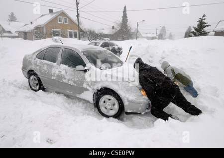 Two men pushing a car stuck in the snow in the Greenwich Village Stock ...