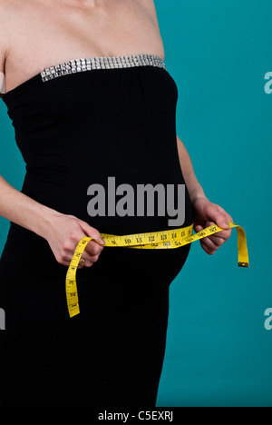 Closeup shot of a pregnant female measuring her belly Stock Photo - Alamy