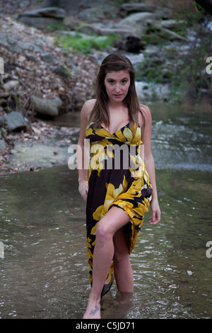 Lovely woman wading in a creek and looking at the camera Stock Photo ...