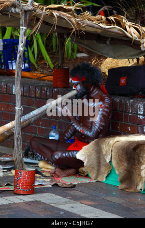 Australian Aborigine man in body paint playing a didgeridoo; Aboriginal ...