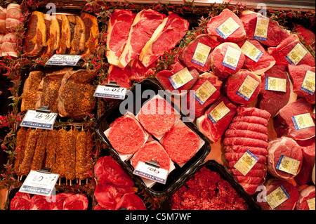 Butchers shop window with various raw joints of meats on display ...