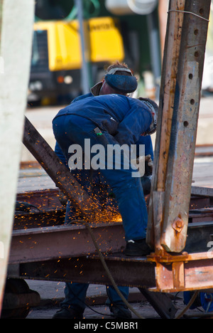 Two men during abrasive cutting in a shipyard Stock Photo - Alamy