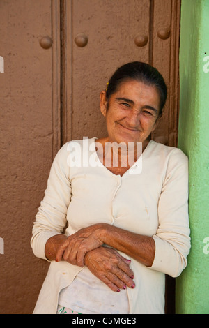 An old Cuban woman, age aged 70s, sitting on her veranda, Vinales town ...
