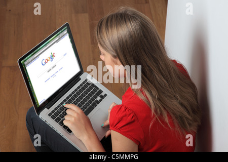 Woman searching internet using Google search engine on an iPad tablet ...