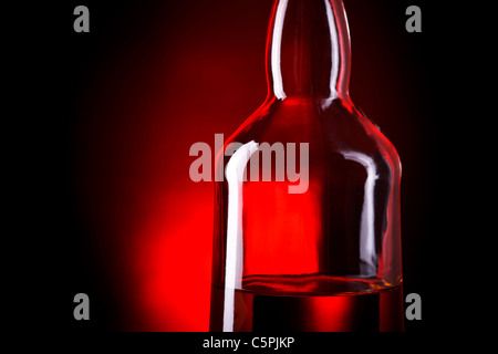 bottle of whiskey on deep red background Stock Photo - Alamy