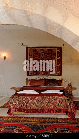 Wrought iron bed with white cushions and linen in bright blue economy ...