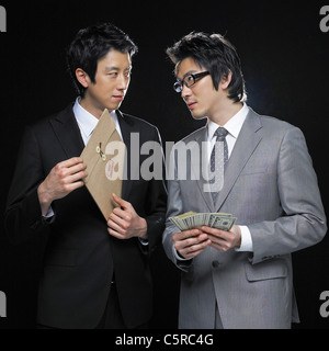Two men exchanging money and information Stock Photo - Alamy