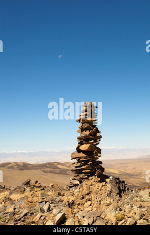A traditional Tibetan stone prayer pile (Mani) and flags by side of ...