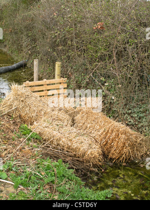 Floating containment barrier and bales of straw being used to clean up ...