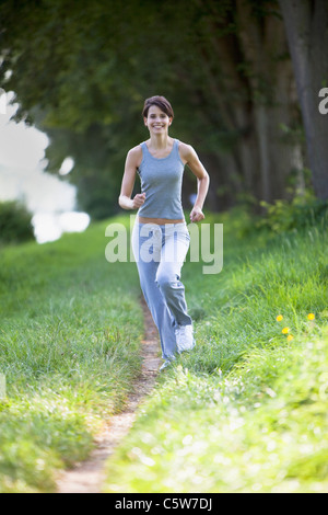 Germany, Bavaria, Young woman jogging at Lake Walchensee Stock Photo ...