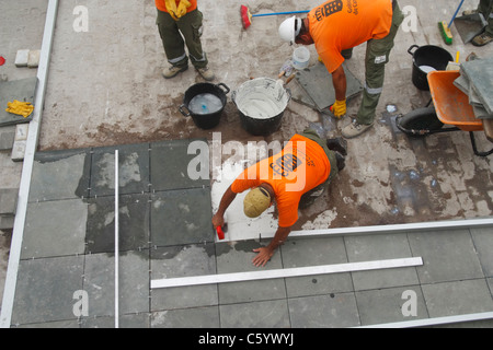 Spanish workman laying paving stones Stock Photo - Alamy