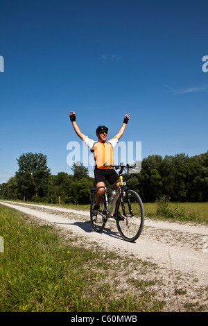 Happy Cyclist Cheering with Arms Raised Stock Photo - Alamy