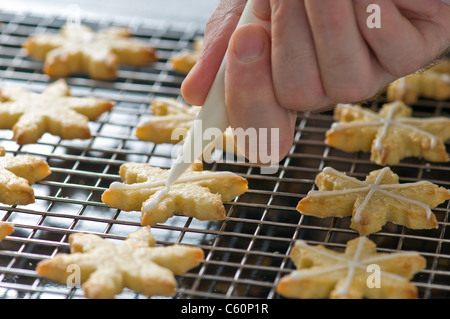 Backer decorates christmas cookies on the backing tray Stock Photo - Alamy