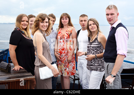 A group of eight 8 young teenagers, 5 boys and 3 girls,friends ...