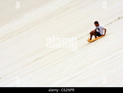 Sliding down a sand dune on a sled in the summer Stock Photo - Alamy